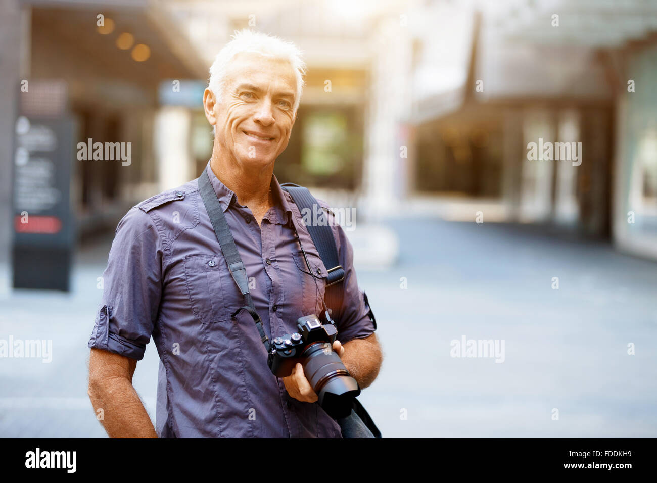Senior man with camera in city Stock Photo - Alamy