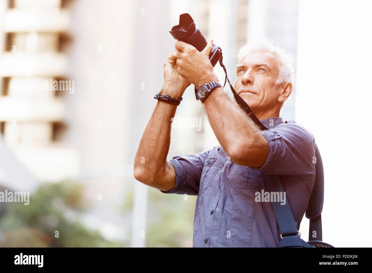 Senior man with camera in city Stock Photo - Alamy
