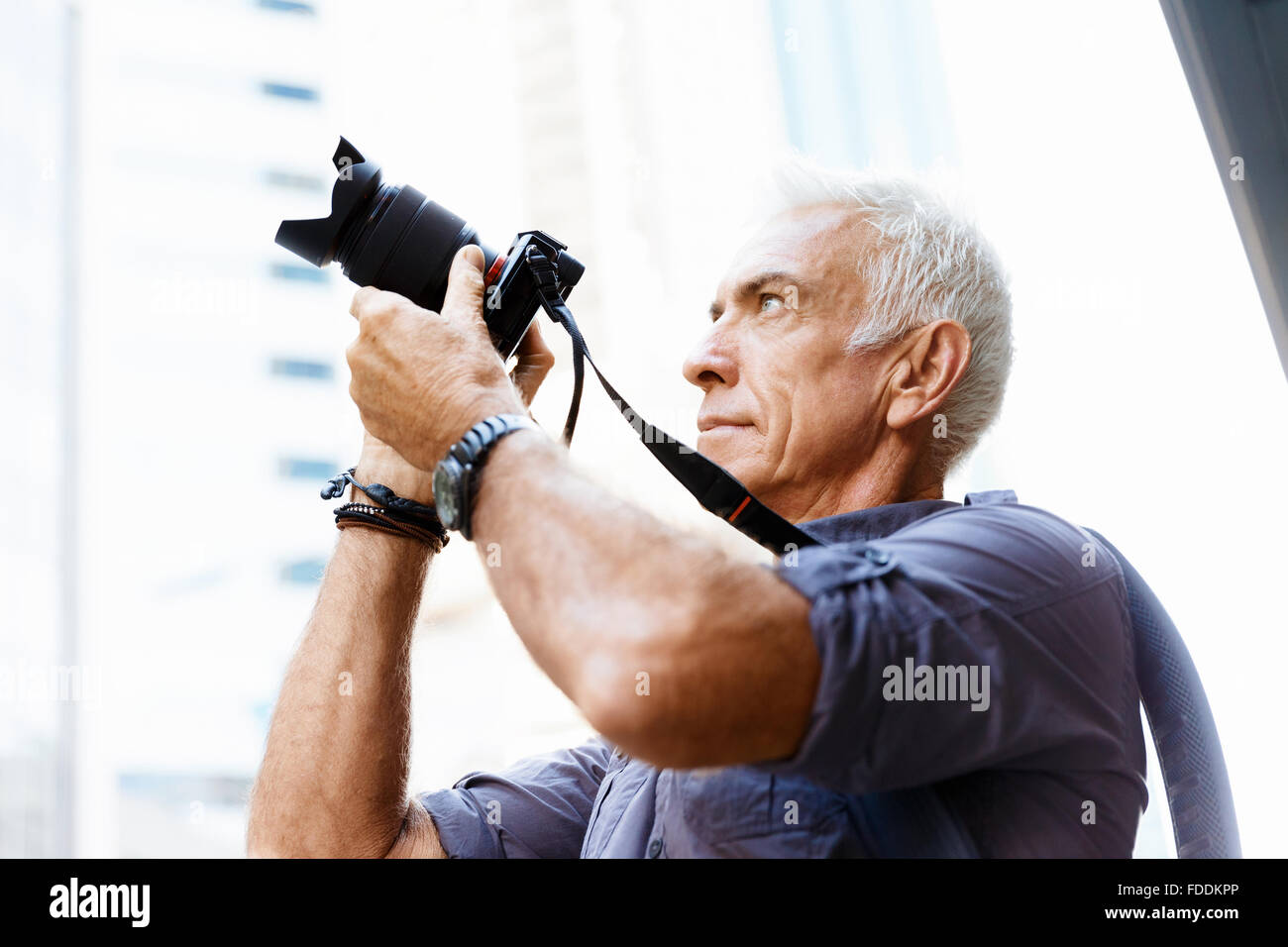 Senior man with camera in city Stock Photo - Alamy
