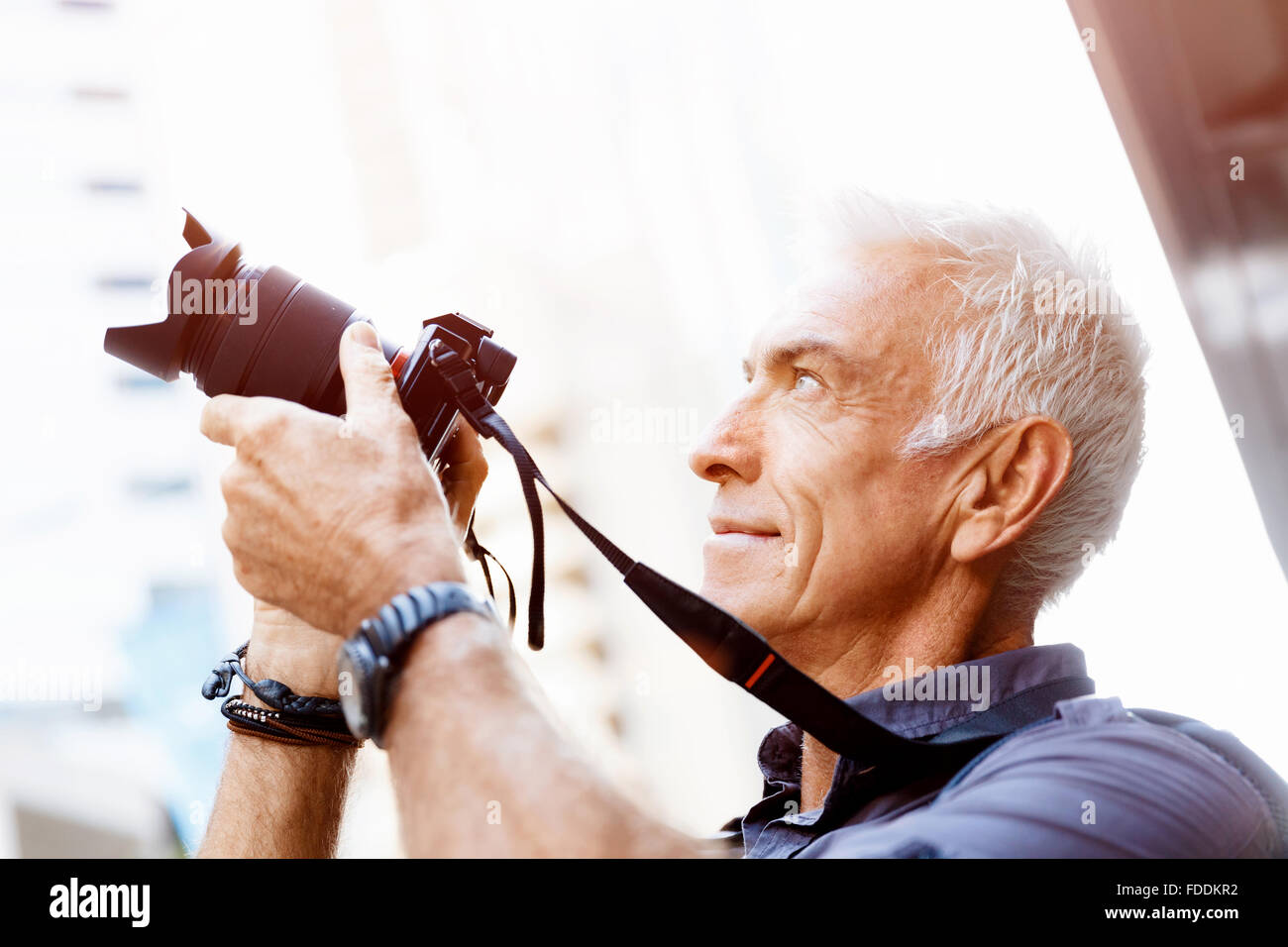 Senior man with camera in city Stock Photo - Alamy