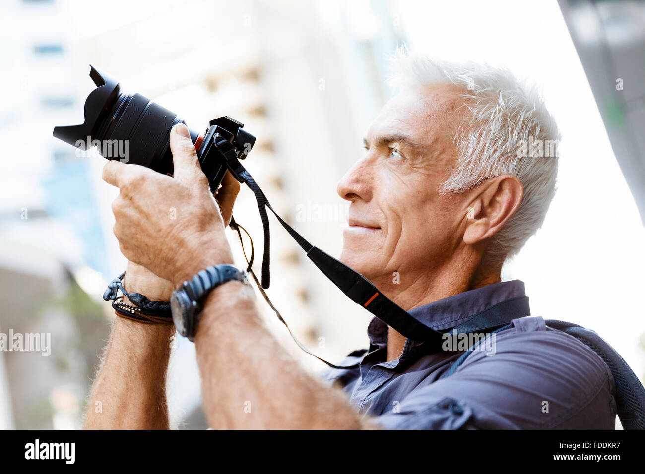 Senior man with camera in city Stock Photo - Alamy
