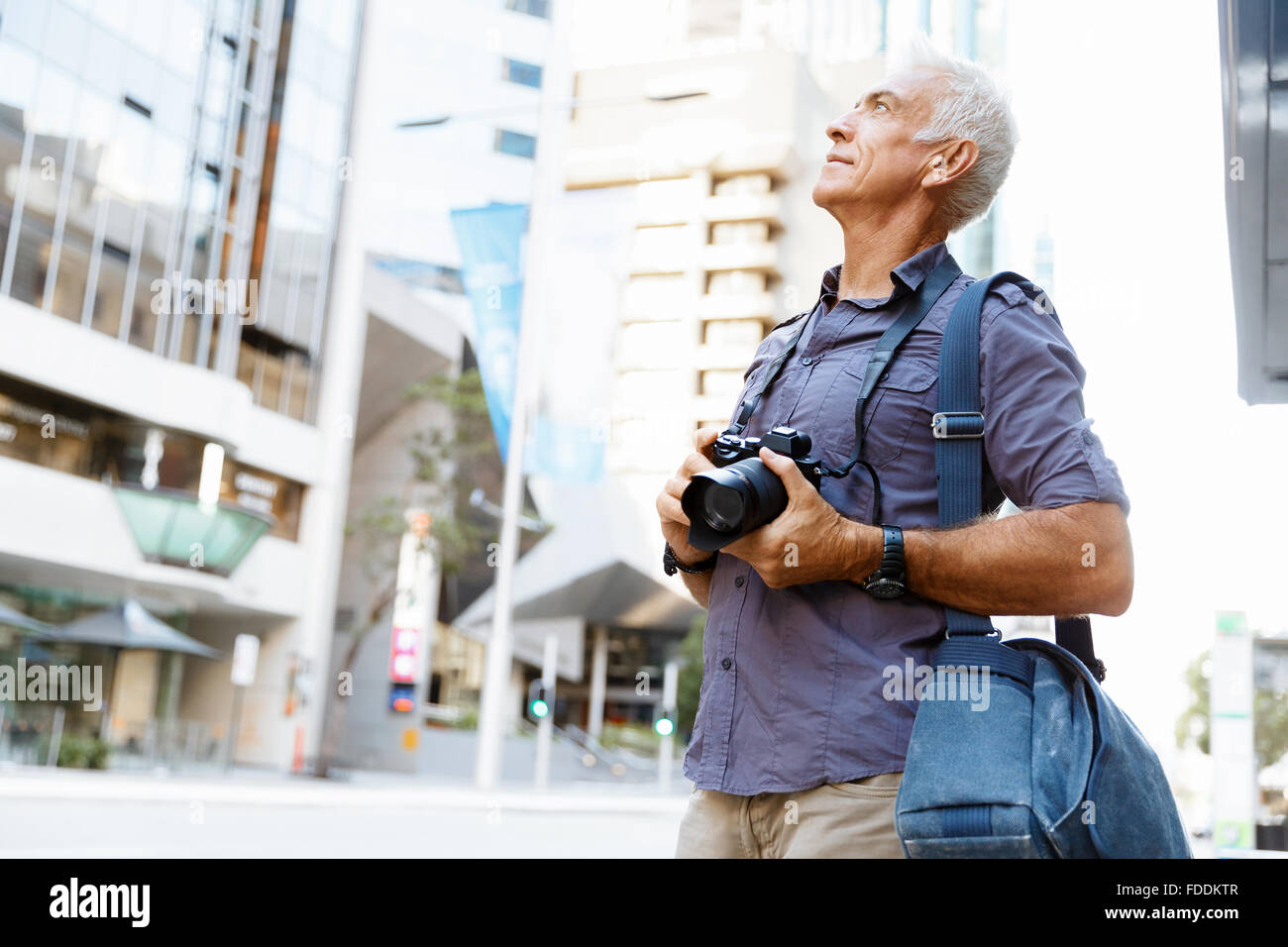 Senior man with camera in city Stock Photo - Alamy