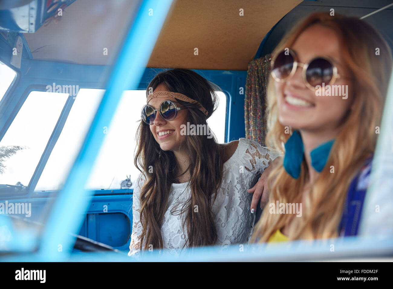 smiling young hippie women driving minivan car Stock Photo - Alamy