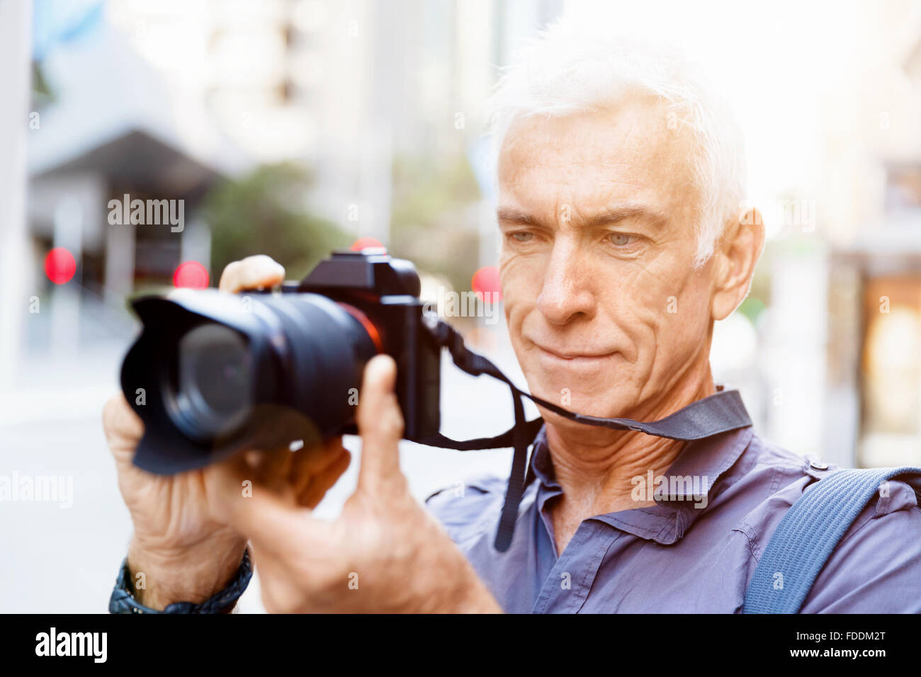 Senior man with camera in city Stock Photo - Alamy