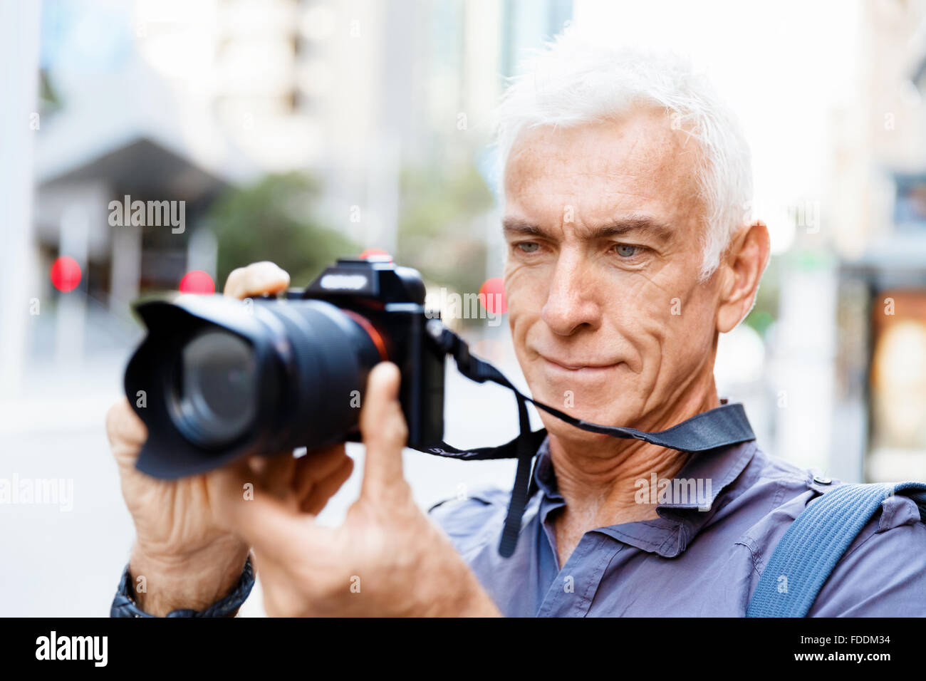 Senior man with camera in city Stock Photo - Alamy