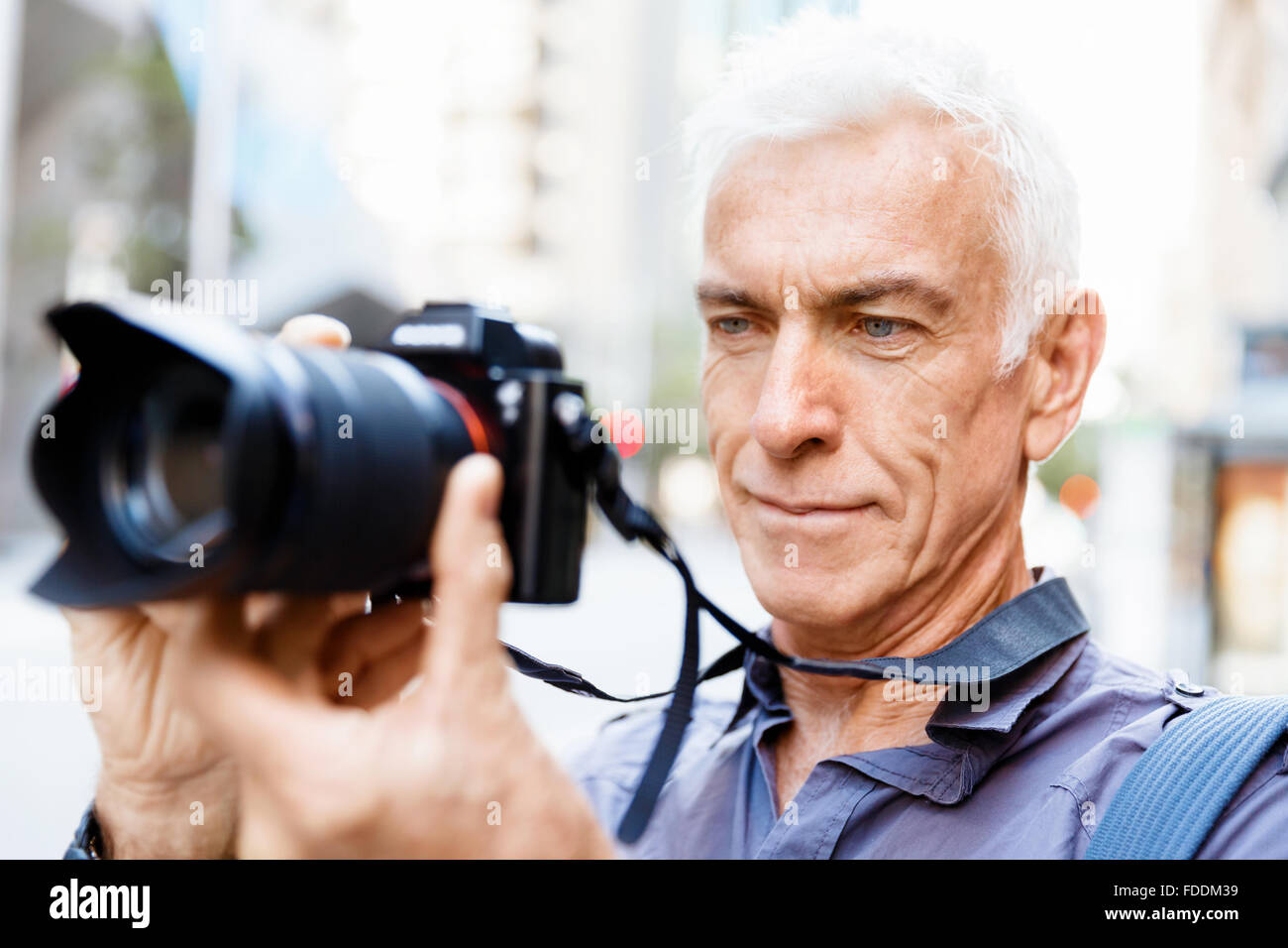 Senior man with camera in city Stock Photo - Alamy