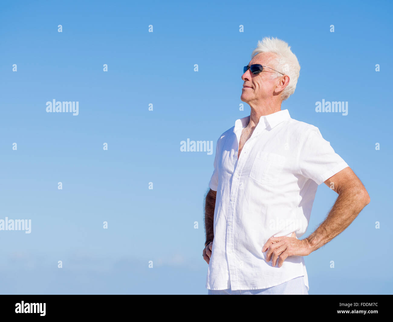 Handsome man against blue sky Stock Photo - Alamy