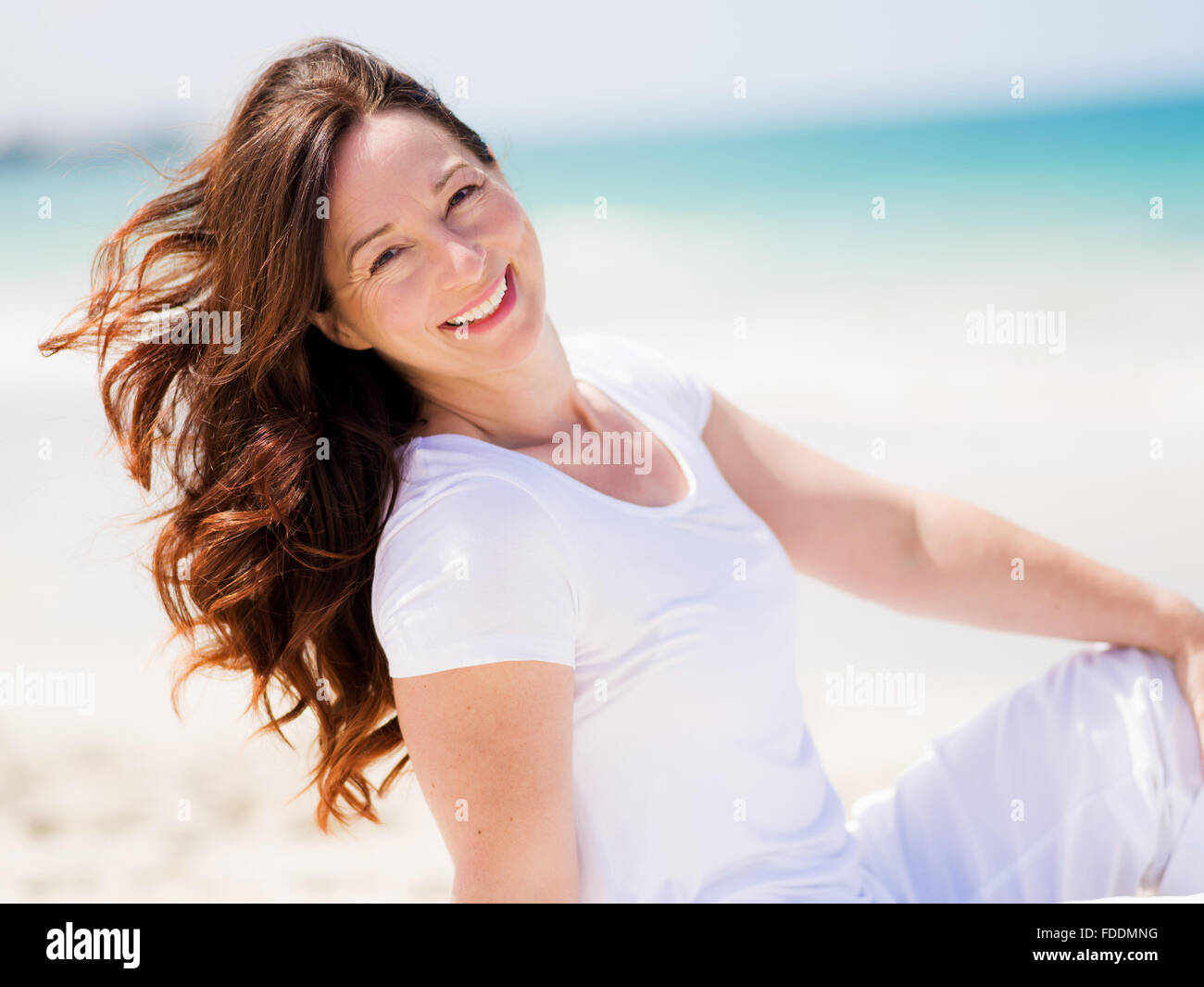 Woman in white clothes on the beach on sunny day Stock Photo - Alamy