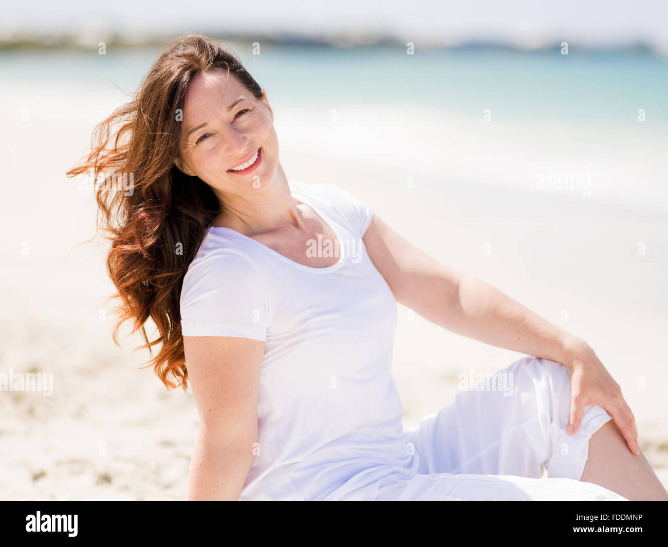 Woman in white clothes on the beach on sunny day Stock Photo - Alamy