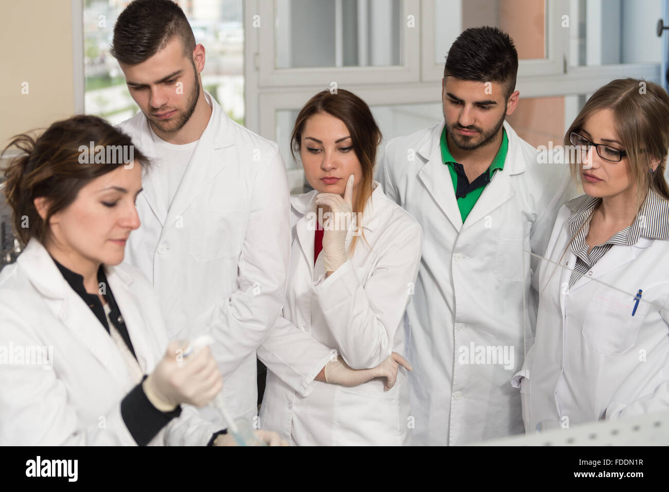 Group Of Students Scientists Conducting Research With Teacher In A Lab ...