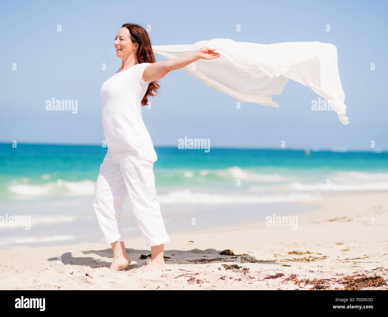 Woman in white clothes on the beach on sunny day Stock Photo - Alamy