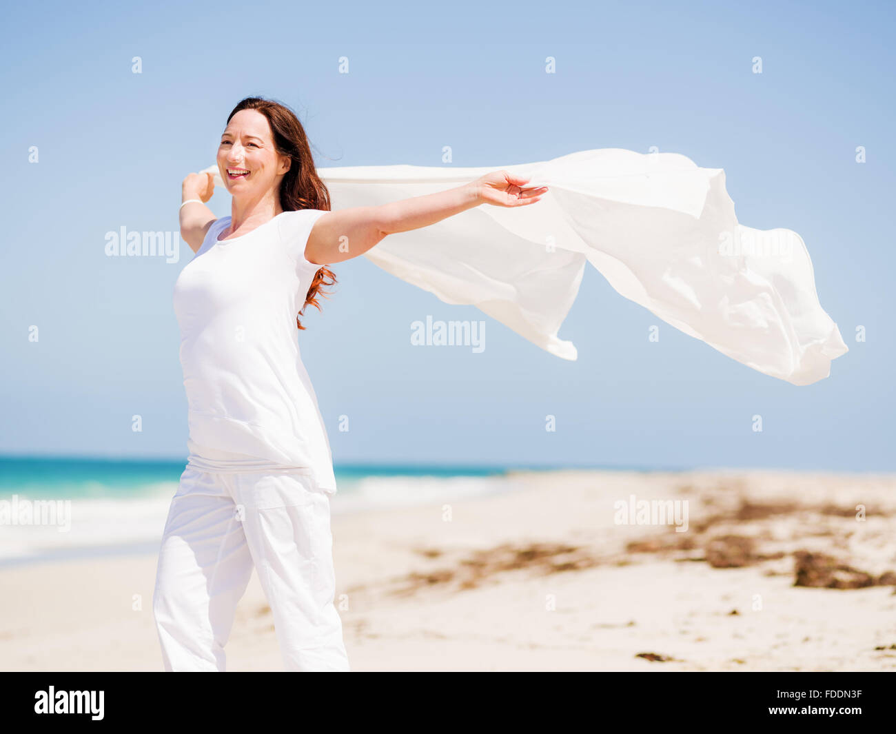 Woman in white clothes on the beach on sunny day Stock Photo - Alamy