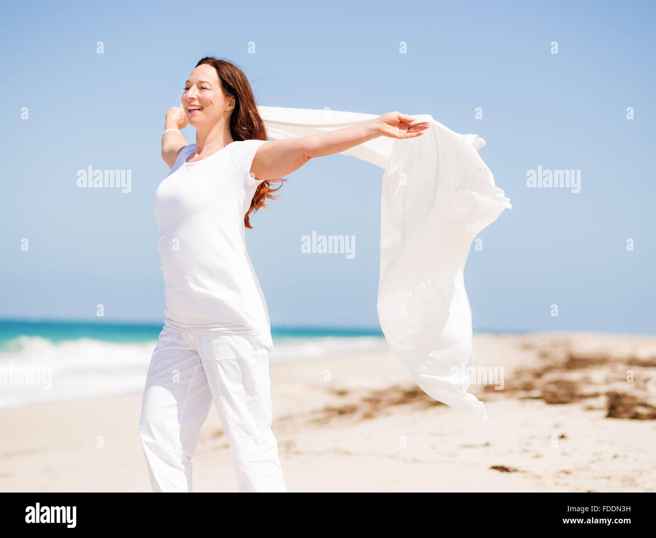 Woman in white clothes on the beach on sunny day Stock Photo - Alamy