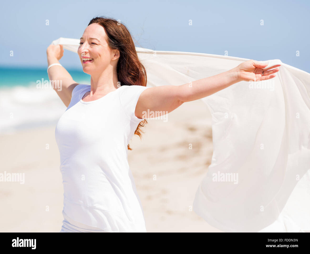 Woman in white clothes on the beach on sunny day Stock Photo - Alamy
