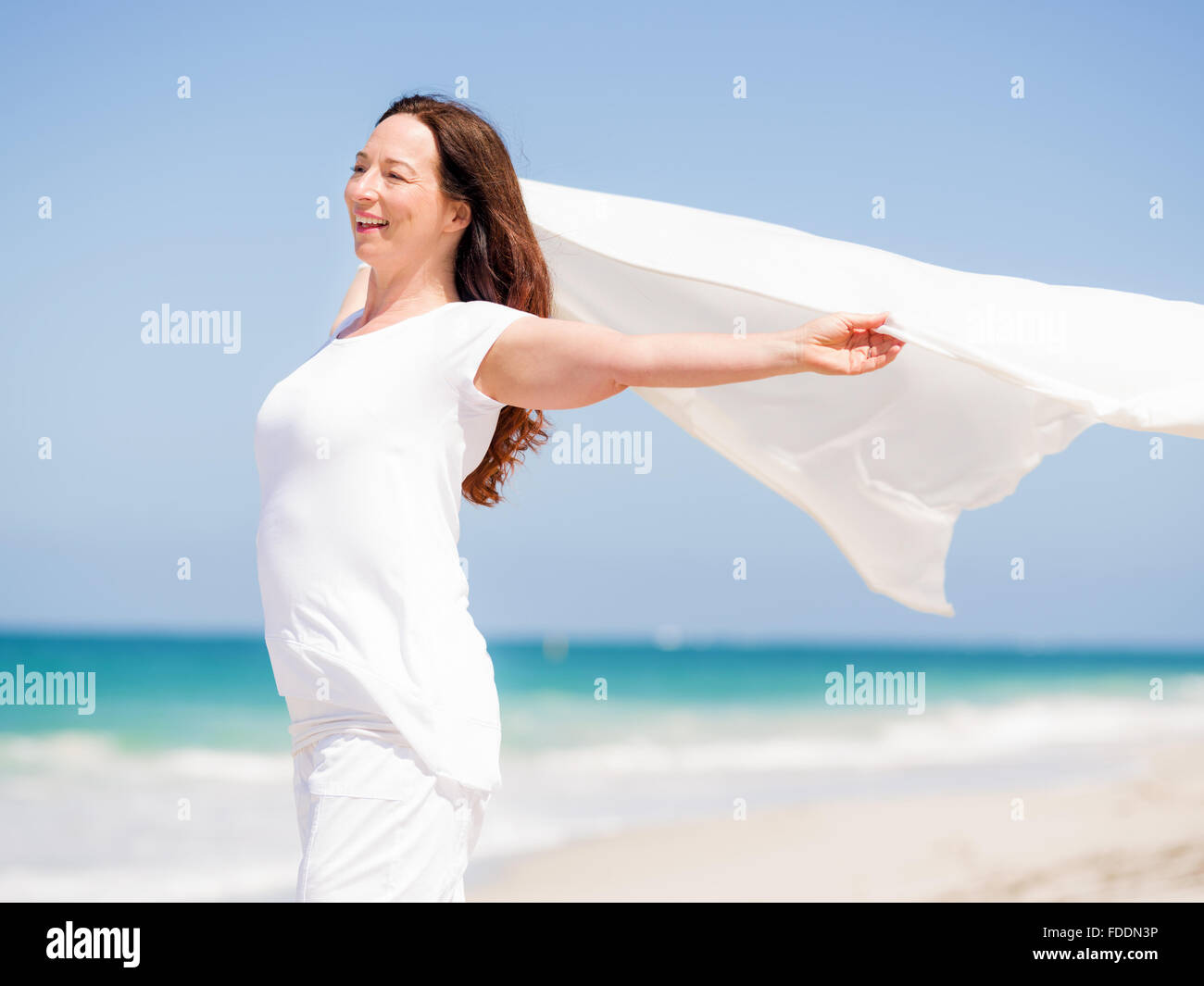 Woman in white clothes on the beach on sunny day Stock Photo - Alamy