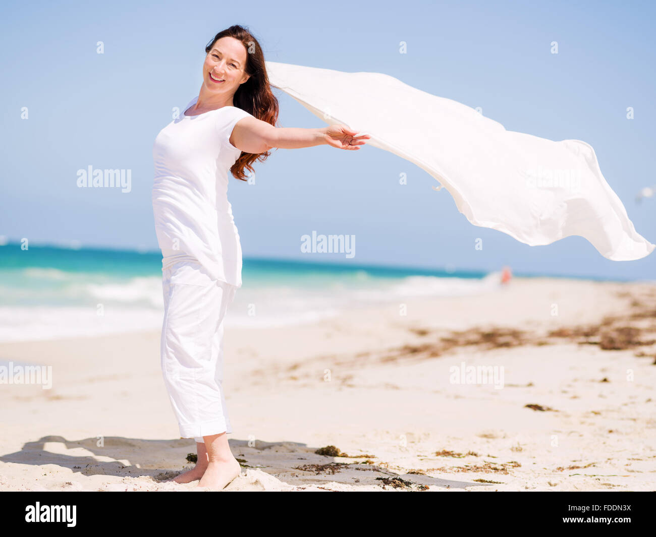 Woman in white clothes on the beach on sunny day Stock Photo - Alamy