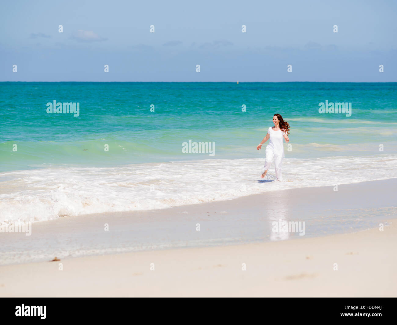 Woman in white clothes on the beach on sunny day Stock Photo - Alamy