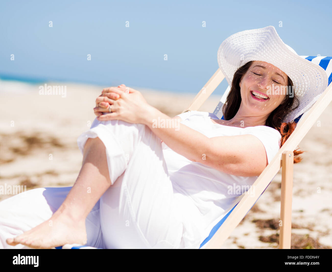 Woman in white clothes on the beach on sunny day Stock Photo - Alamy