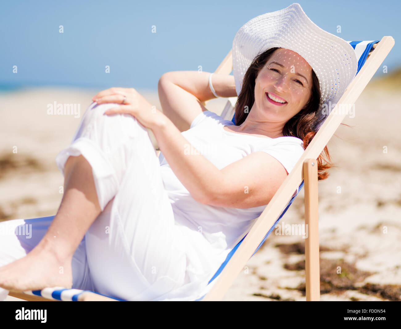 Woman in white clothes on the beach on sunny day Stock Photo - Alamy