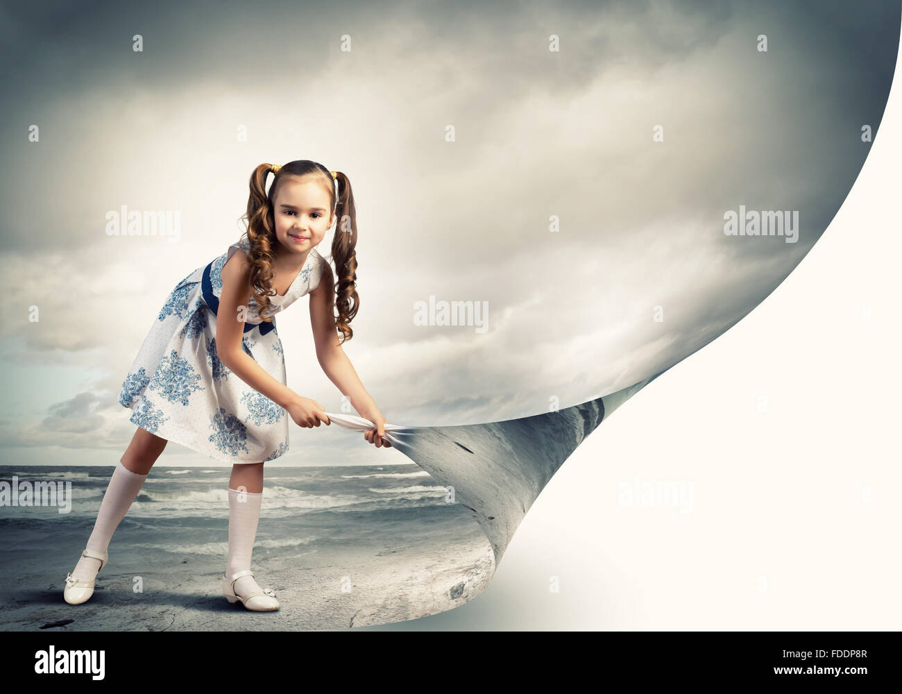 Little girl turning page with another reality Stock Photo - Alamy
