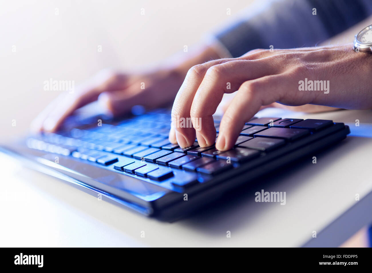 Click! Hands of a man on a keyboard with blue backlighting Stock Photo ...