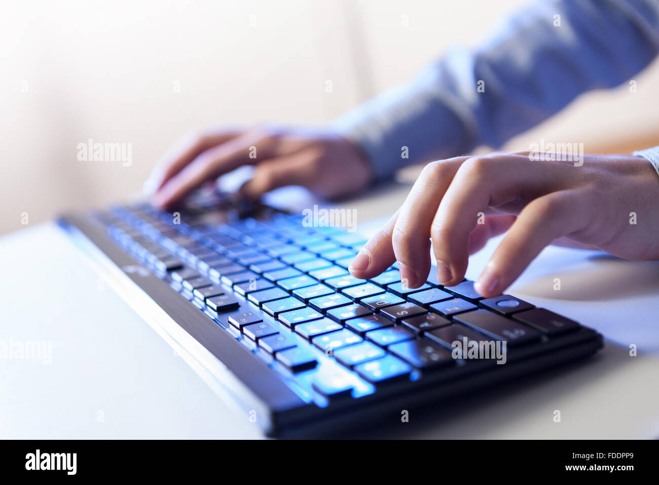 Click! Hands of a man on a keyboard with blue backlighting Stock Photo ...