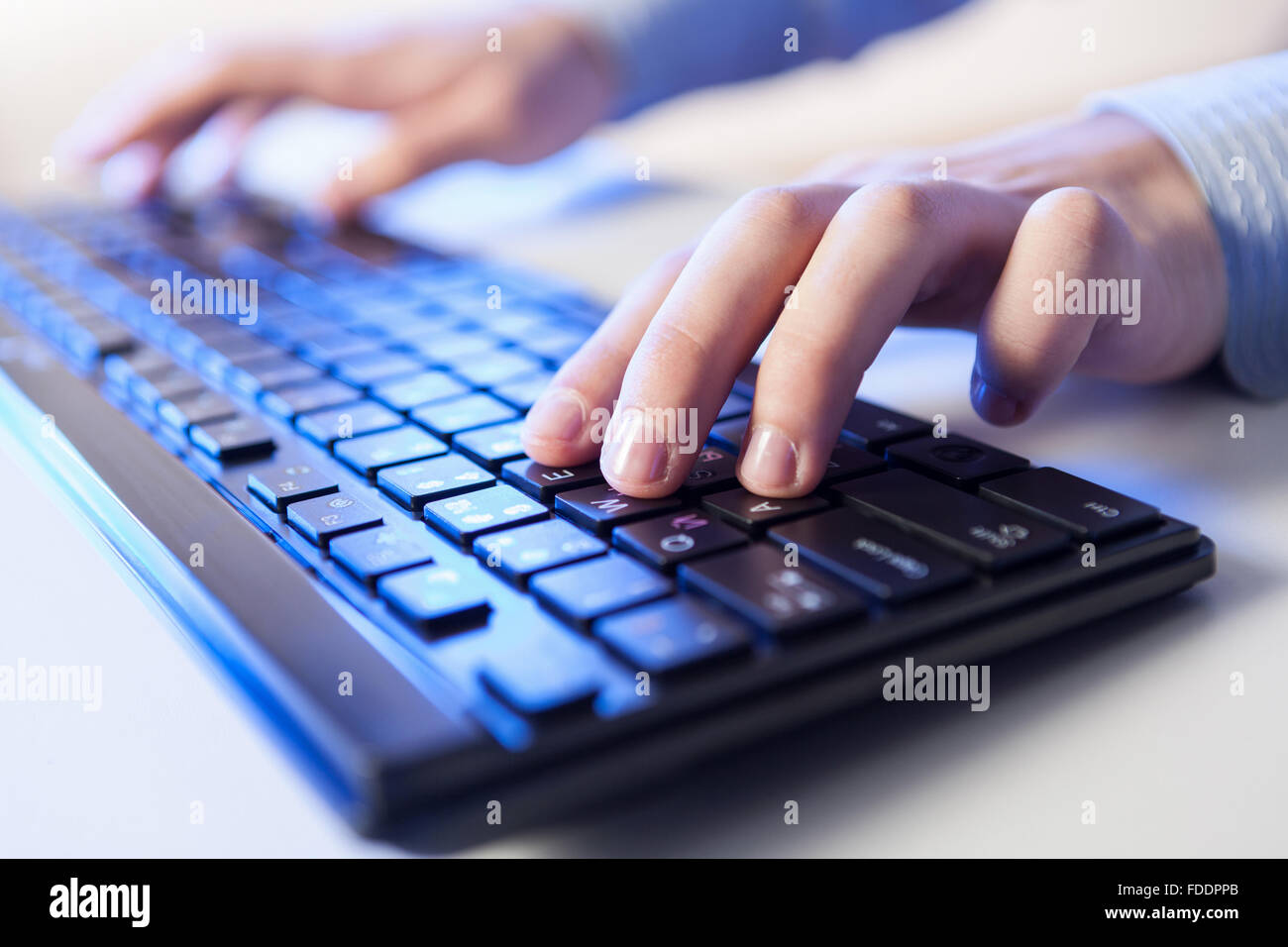 Click! Hands of a man on a keyboard with blue backlighting Stock Photo ...