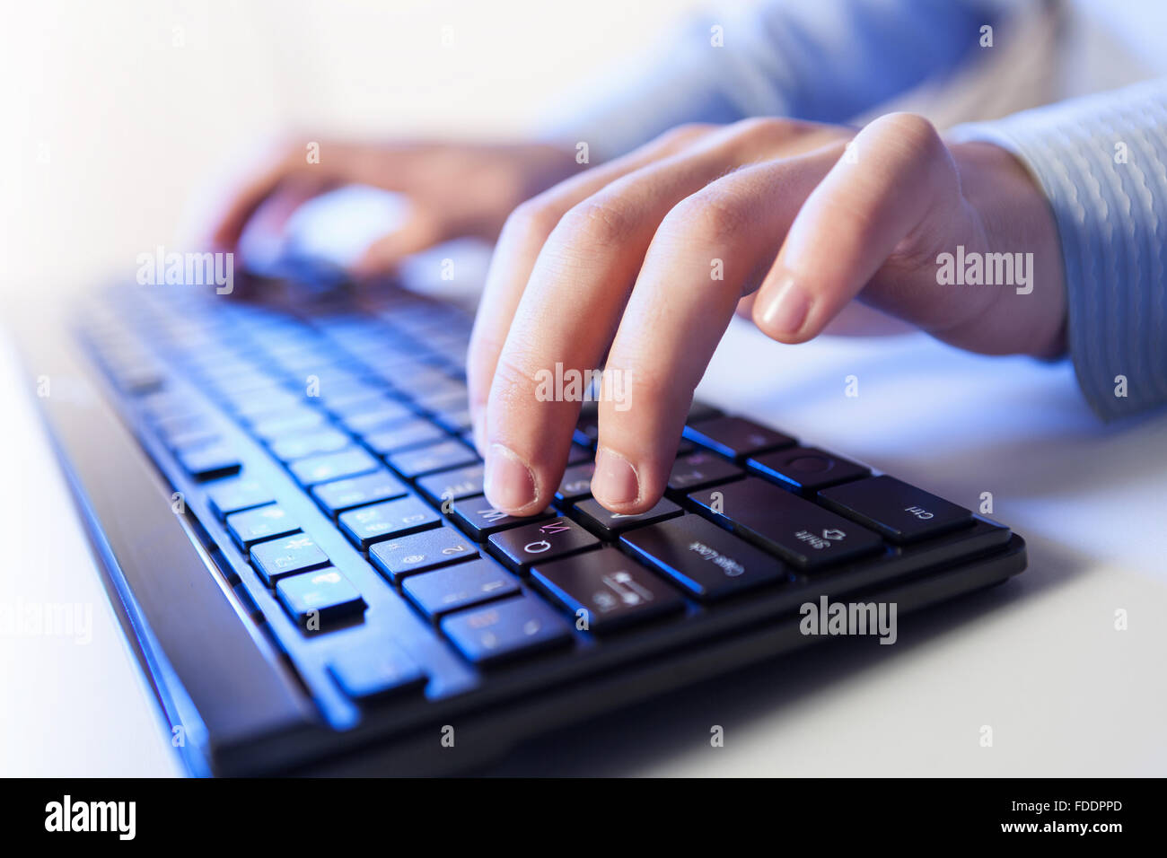 Click! Hands of a man on a keyboard with blue backlighting Stock Photo ...