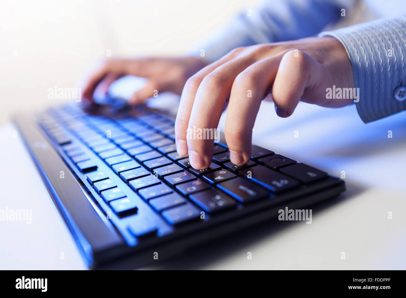 Click! Hands of a man on a keyboard with blue backlighting Stock Photo ...