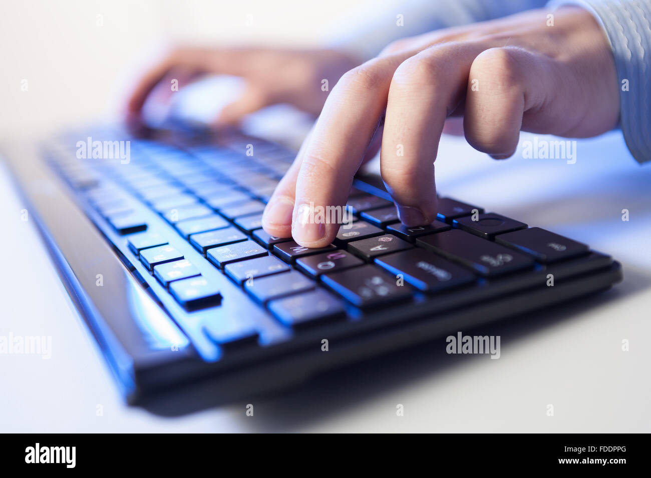 Click! Hands of a man on a keyboard with blue backlighting Stock Photo ...