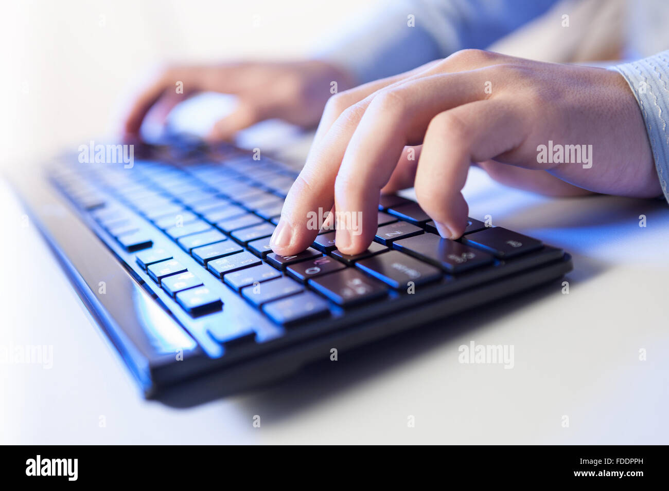 Click! Hands of a man on a keyboard with blue backlighting Stock Photo ...