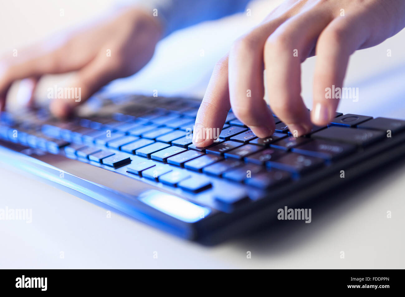 Click! Hands of a man on a keyboard with blue backlighting Stock Photo ...