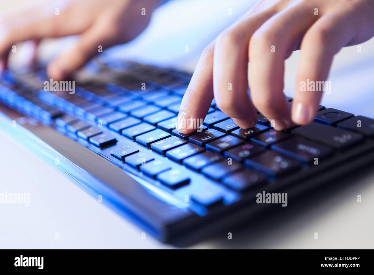 Click! Hands of a man on a keyboard with blue backlighting Stock Photo ...