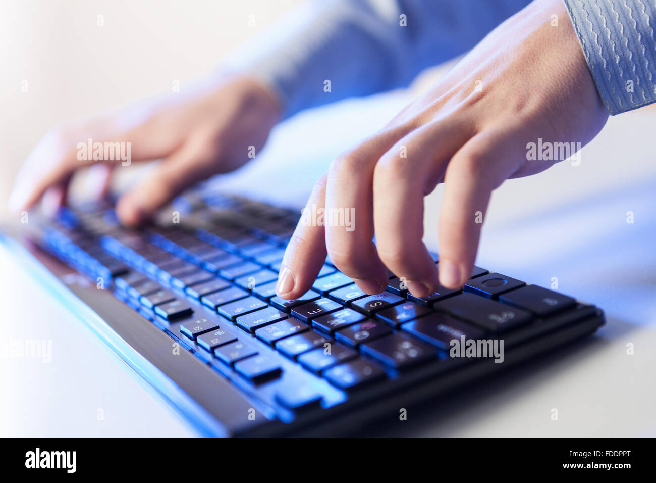 Click! Hands of a man on a keyboard with blue backlighting Stock Photo ...
