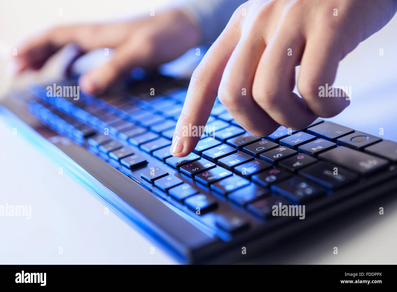 Click! Hands of a man on a keyboard with blue backlighting Stock Photo ...