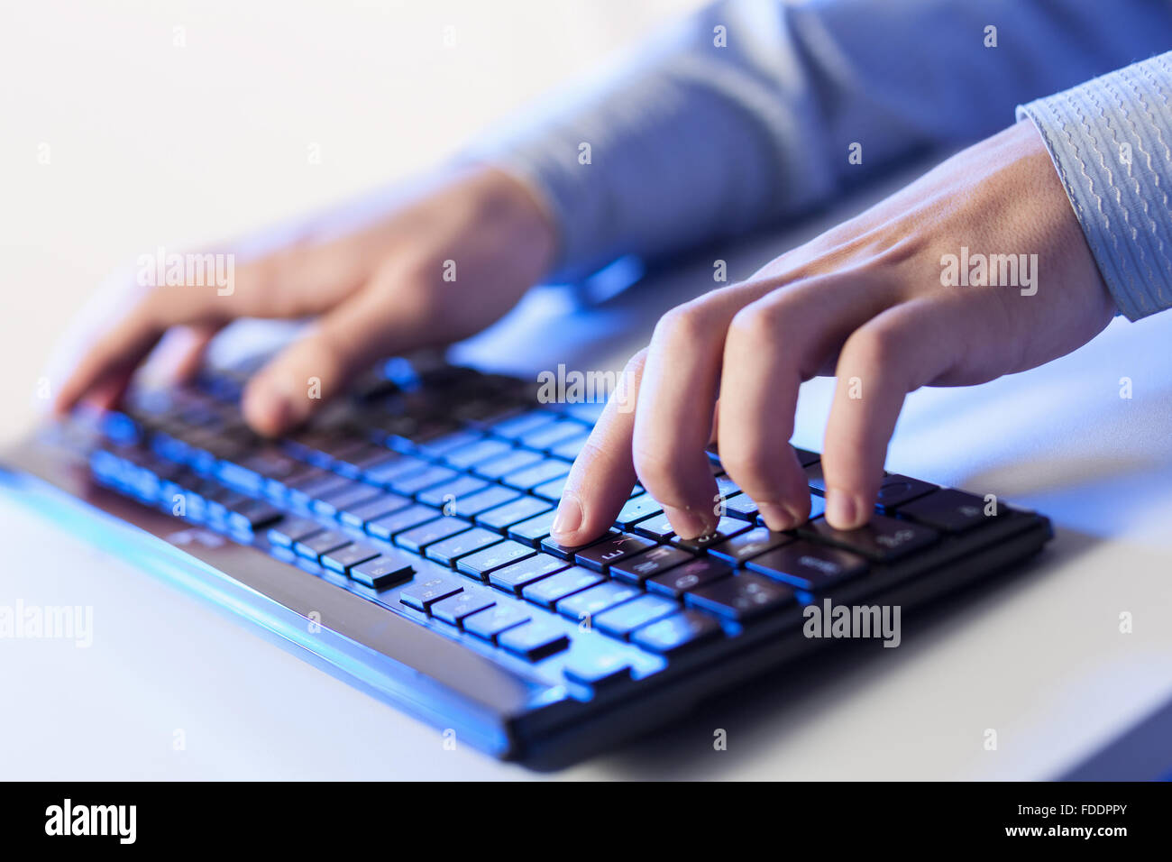 Click! Hands of a man on a keyboard with blue backlighting Stock Photo ...