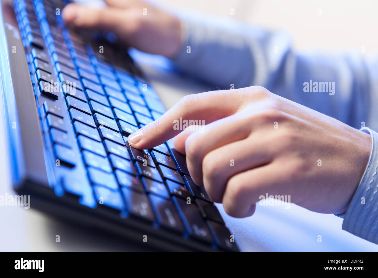 Click! Hands of a man on a keyboard with blue backlighting Stock Photo ...