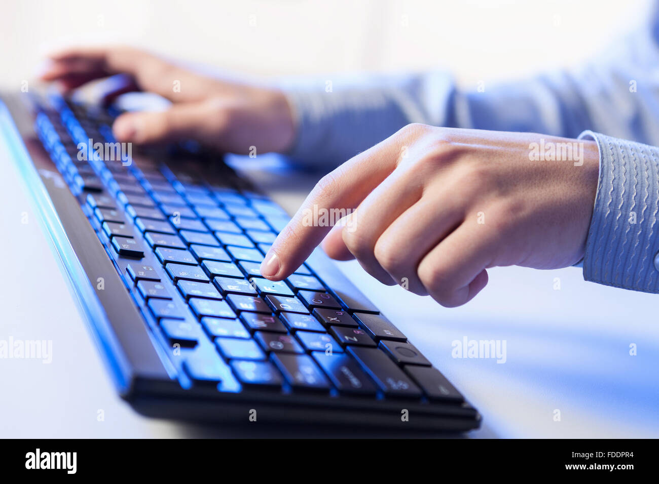 Click! Hands of a man on a keyboard with blue backlighting Stock Photo ...