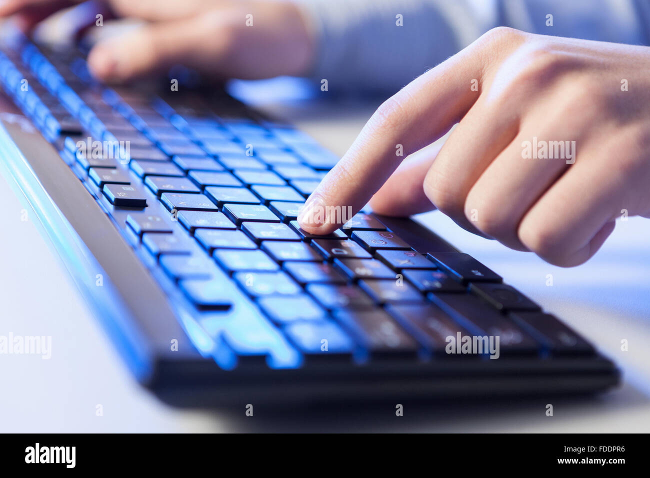 Click! Hands of a man on a keyboard with blue backlighting Stock Photo ...