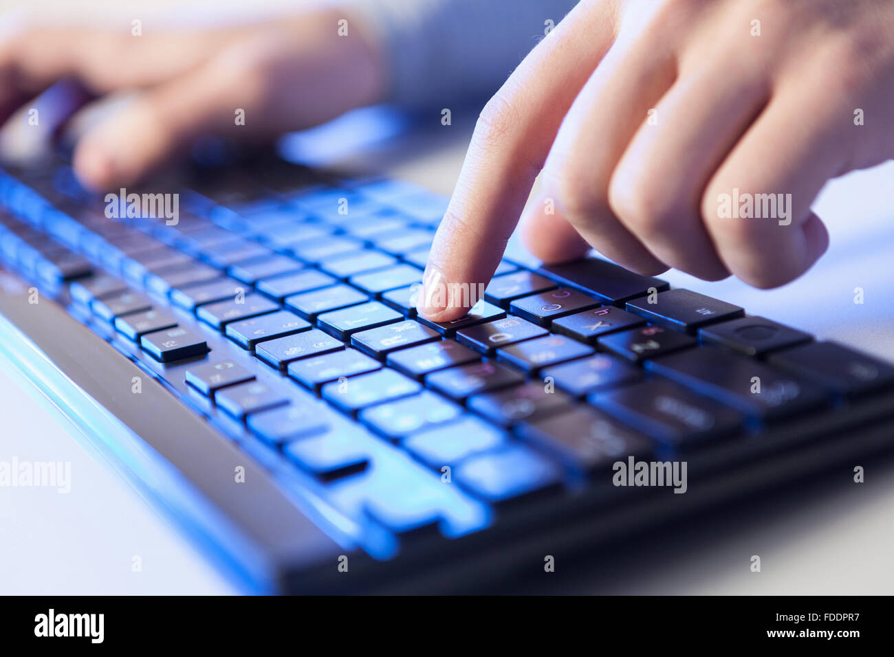 Click! Hands of a man on a keyboard with blue backlighting Stock Photo ...