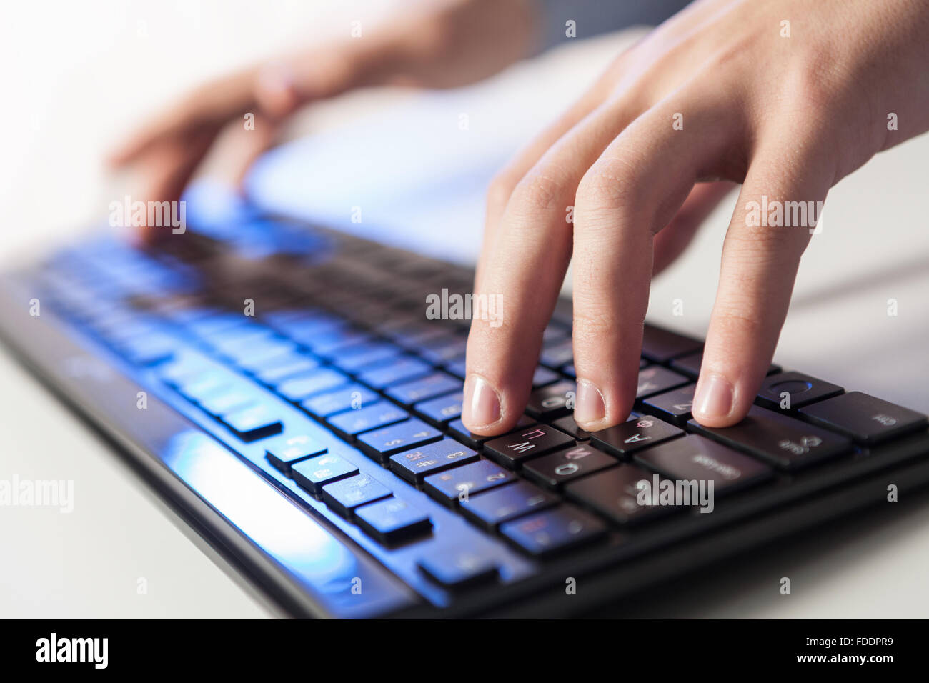 Click! Hands of a man on a keyboard with blue backlighting Stock Photo ...