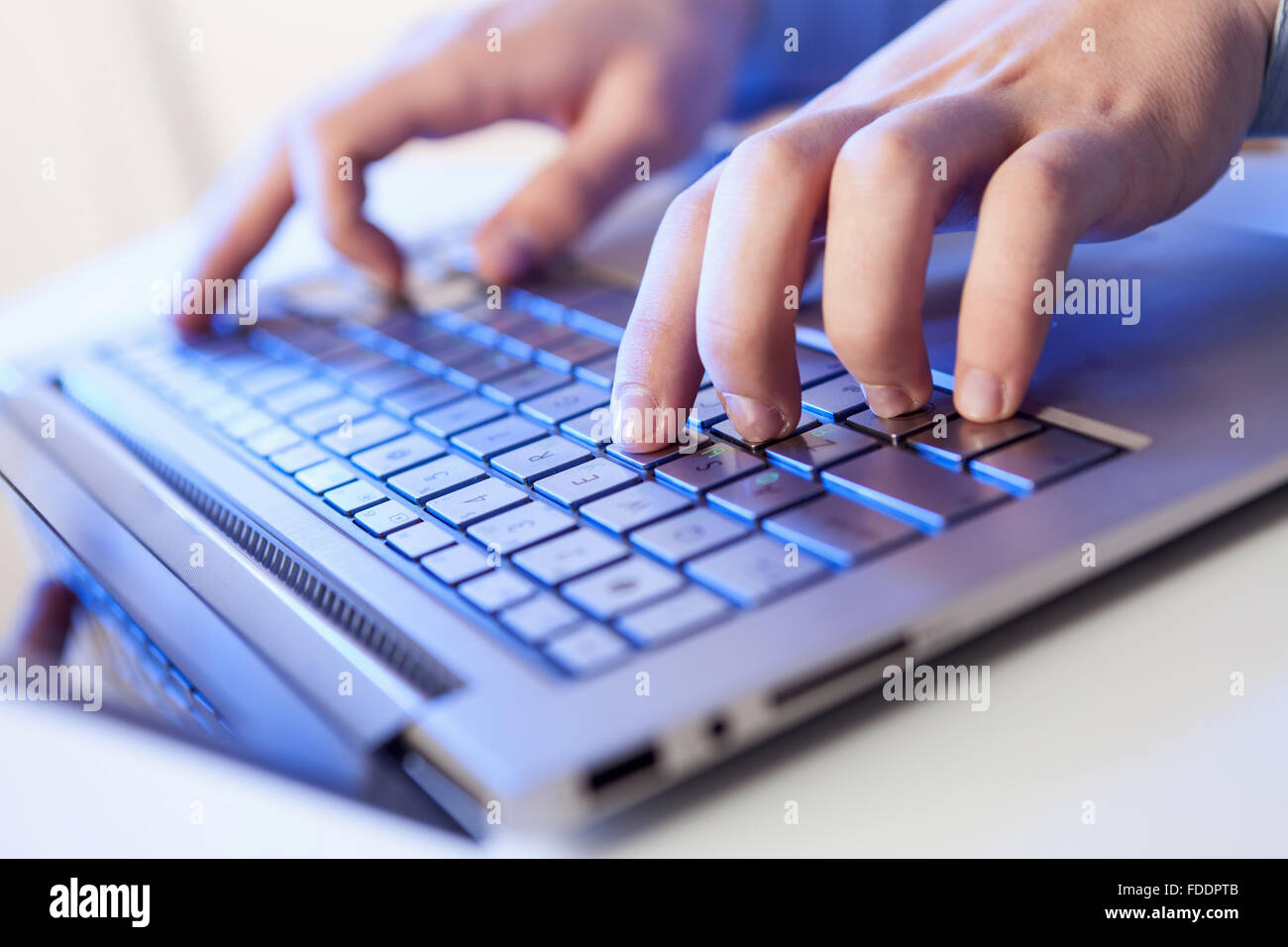 Click! Hands of a man on a keyboard with blue backlighting Stock Photo ...