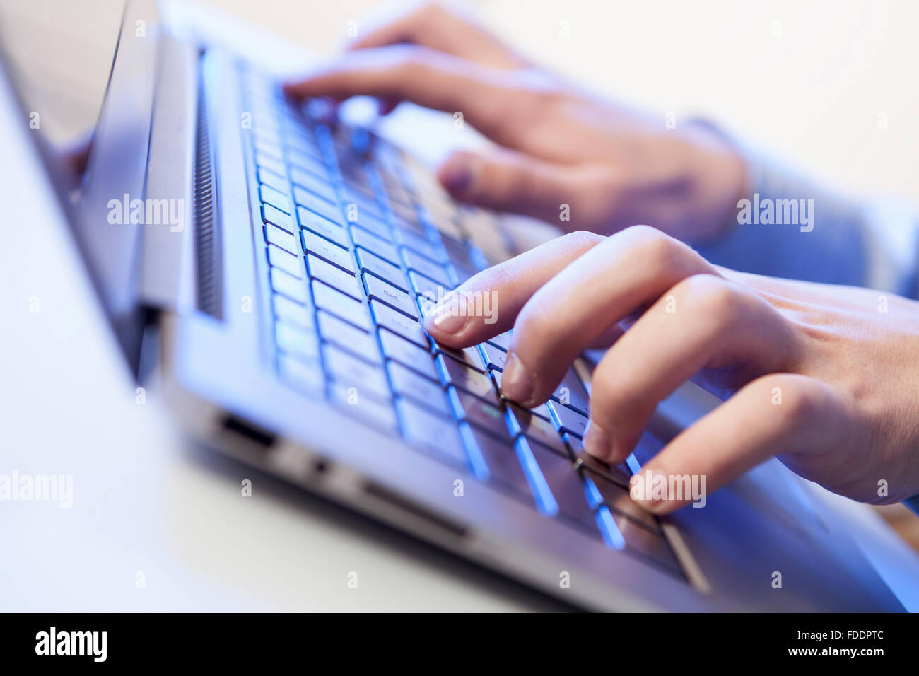 Click! Hands of a man on a keyboard with blue backlighting Stock Photo ...
