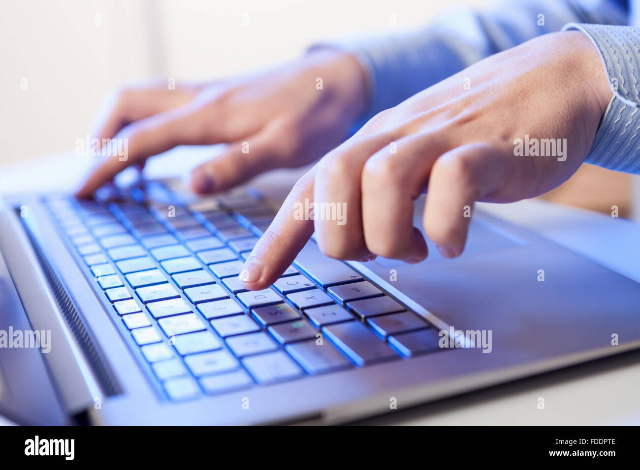 Click! Hands of a man on a keyboard with blue backlighting Stock Photo ...