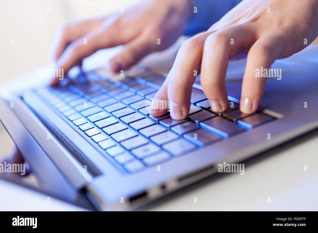 Click! Hands of a man on a keyboard with blue backlighting Stock Photo ...