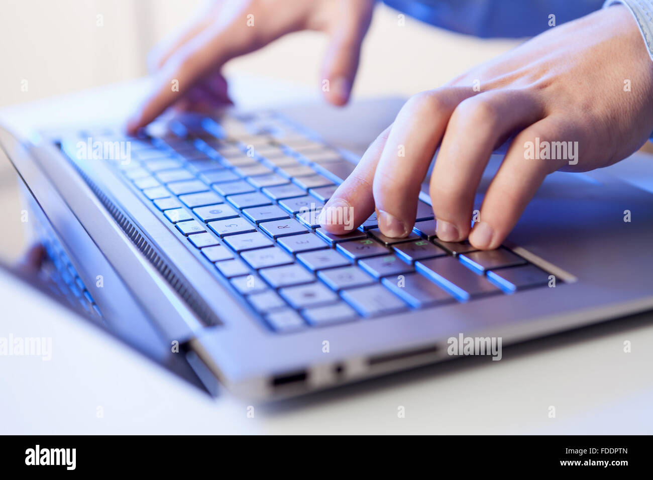Click! Hands of a man on a keyboard with blue backlighting Stock Photo ...