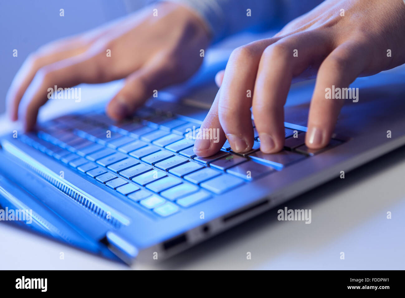 Click! Hands of a man on a keyboard with blue backlighting Stock Photo ...