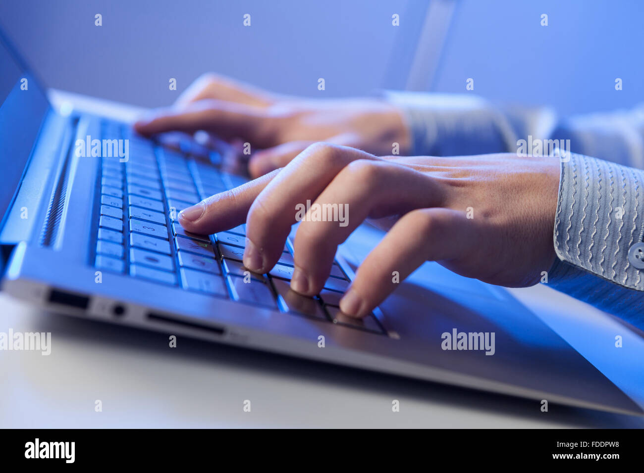 Click! Hands of a man on a keyboard with blue backlighting Stock Photo ...
