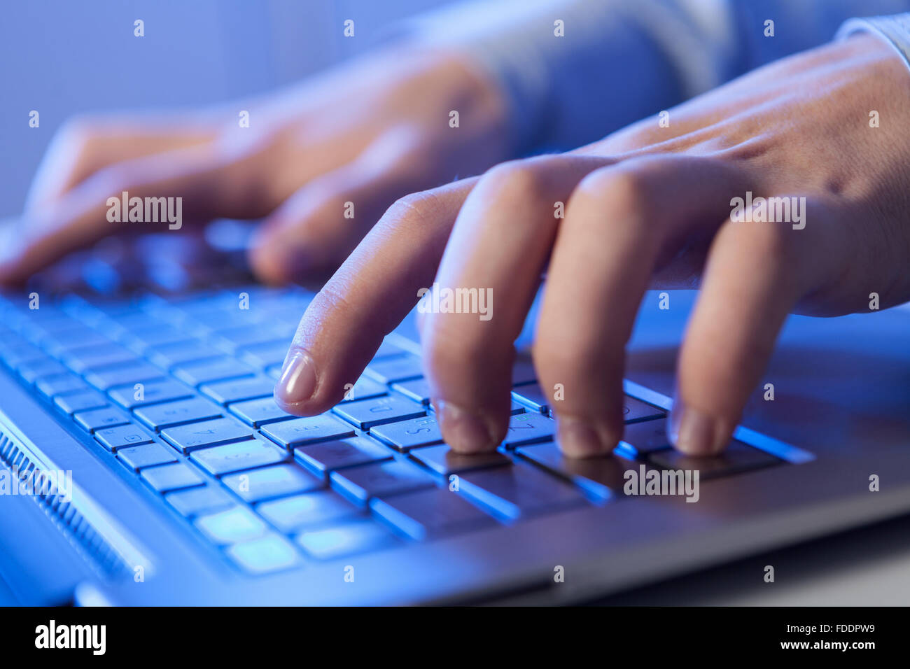 Click! Hands of a man on a keyboard with blue backlighting Stock Photo ...