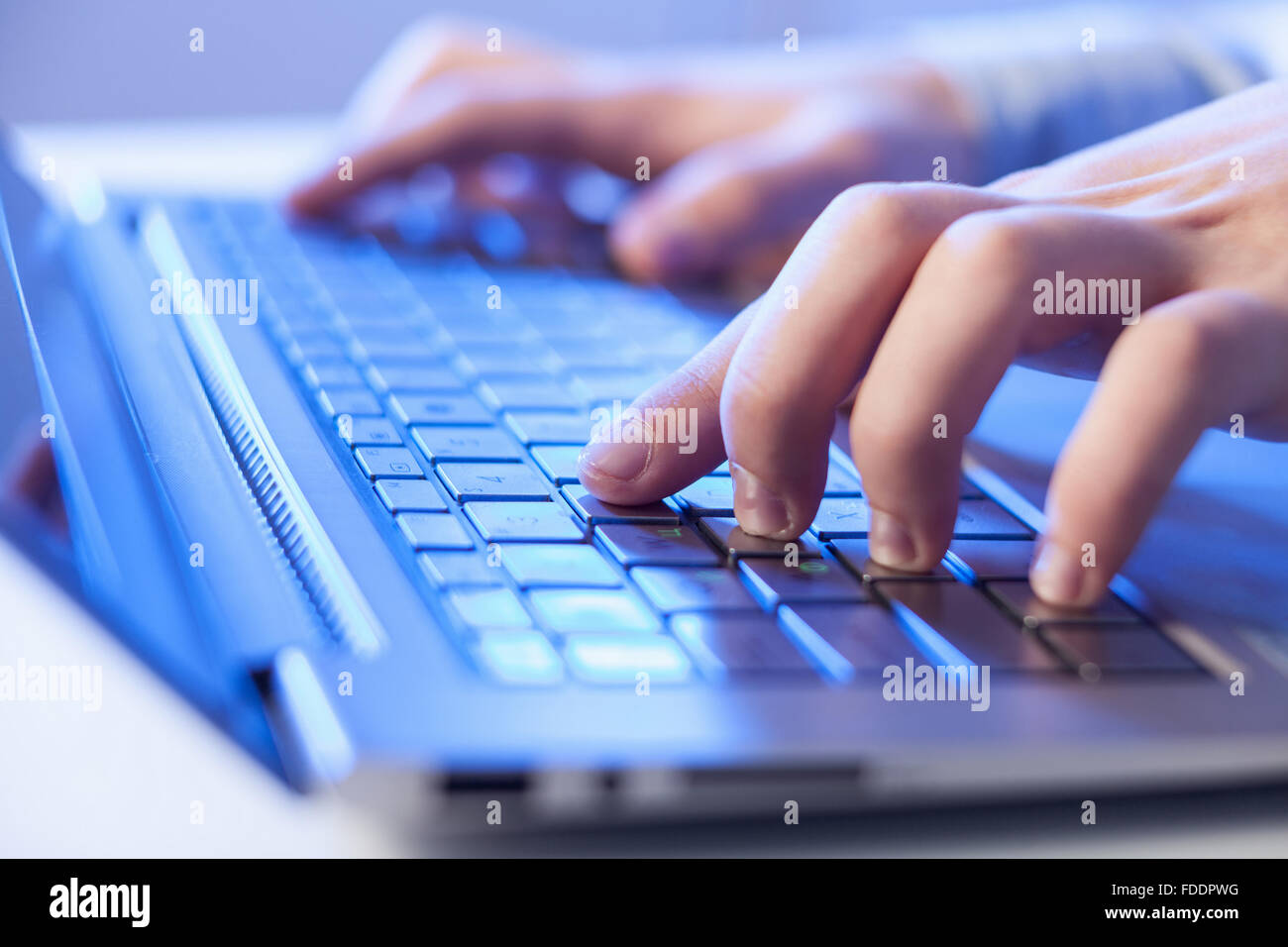 Click! Hands of a man on a keyboard with blue backlighting Stock Photo ...